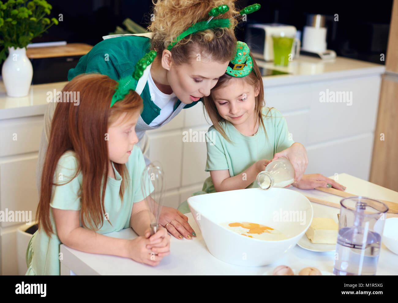 Mother teaching her children how to bake cupcake Stock Photo - Alamy