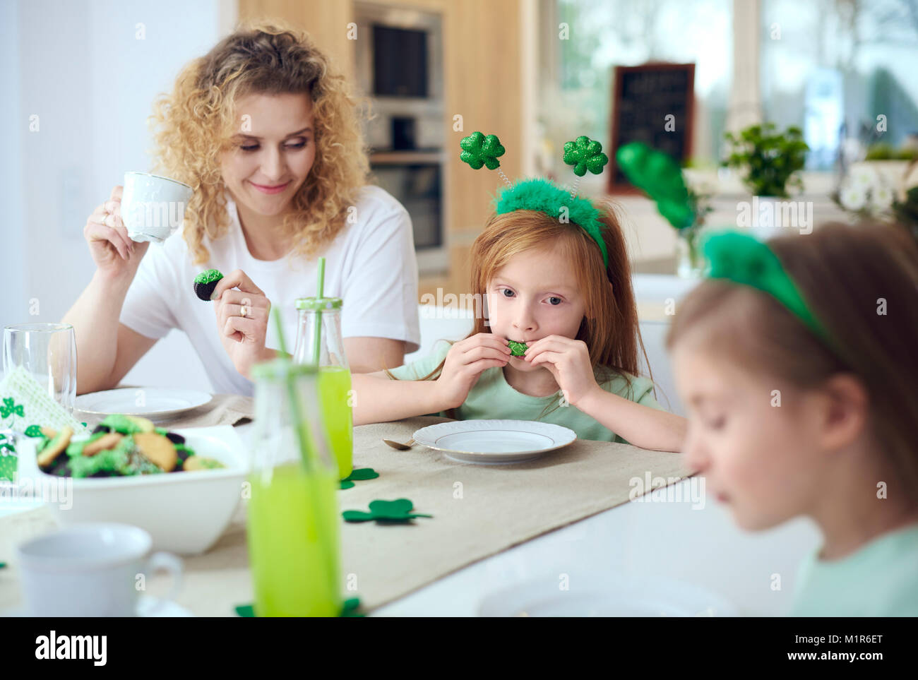 Family eating tasty cookies at the table Stock Photo - Alamy
