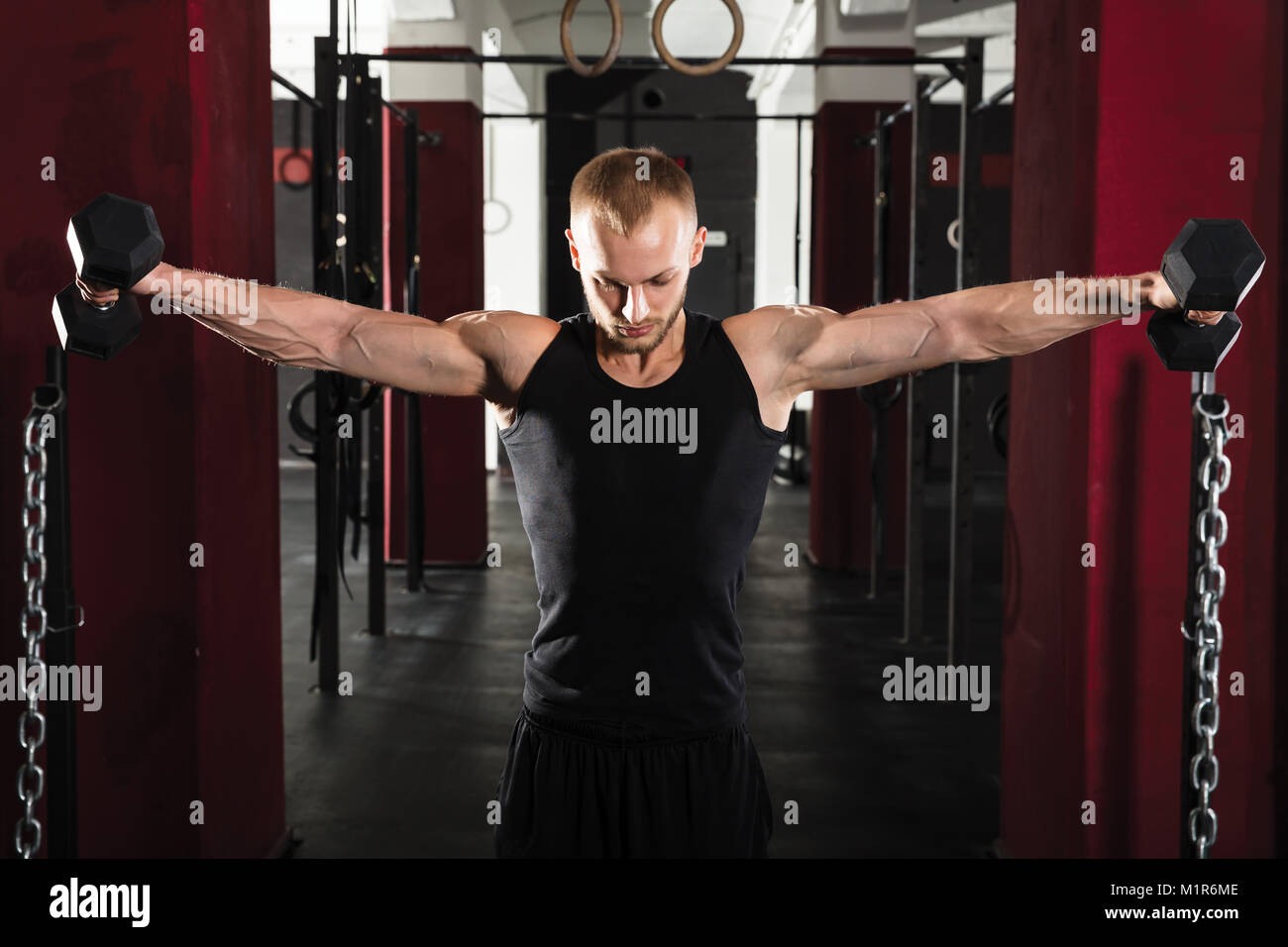 Portrait Of A Young Man Working Out With Dumbbell In Gym Stock Photo ...