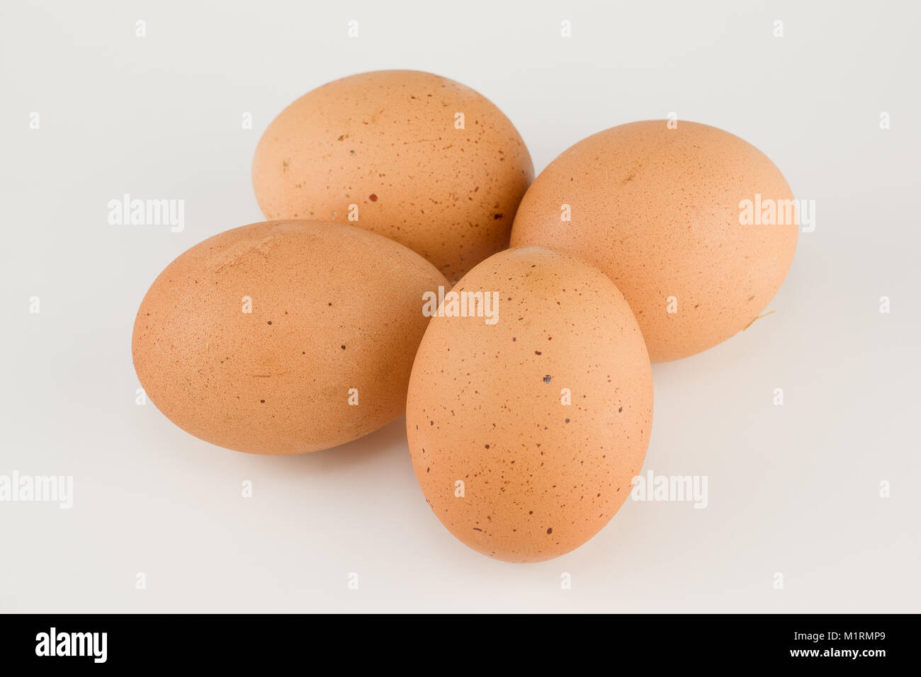 Four fresh rustic eggs isolated on white background Stock Photo - Alamy