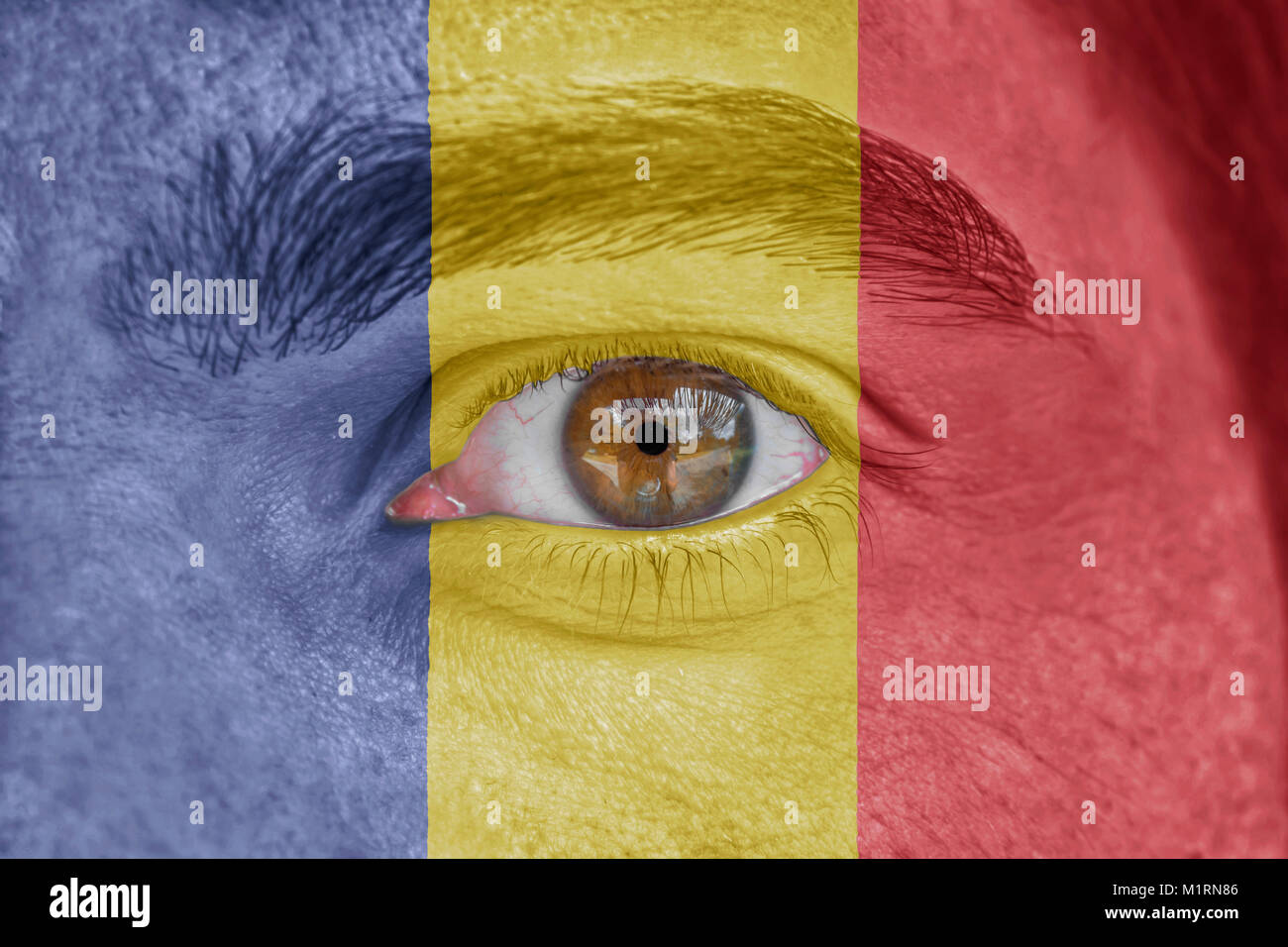 Human face and eye painted with flag of Romania Stock Photo - Alamy