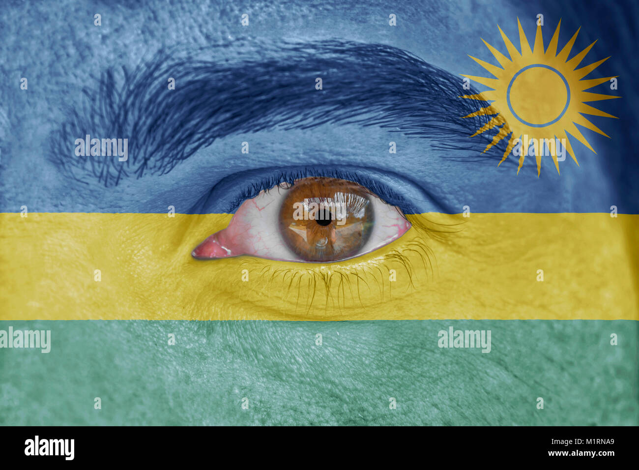 Human face and eye painted with flag of Rwanda Stock Photo - Alamy
