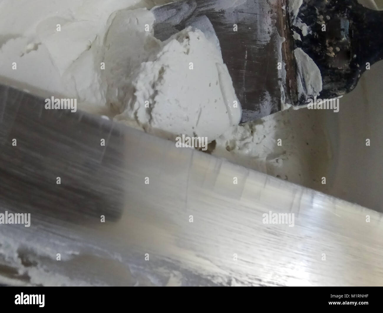 spatula and plaster construction work in the building interior upgrade ...