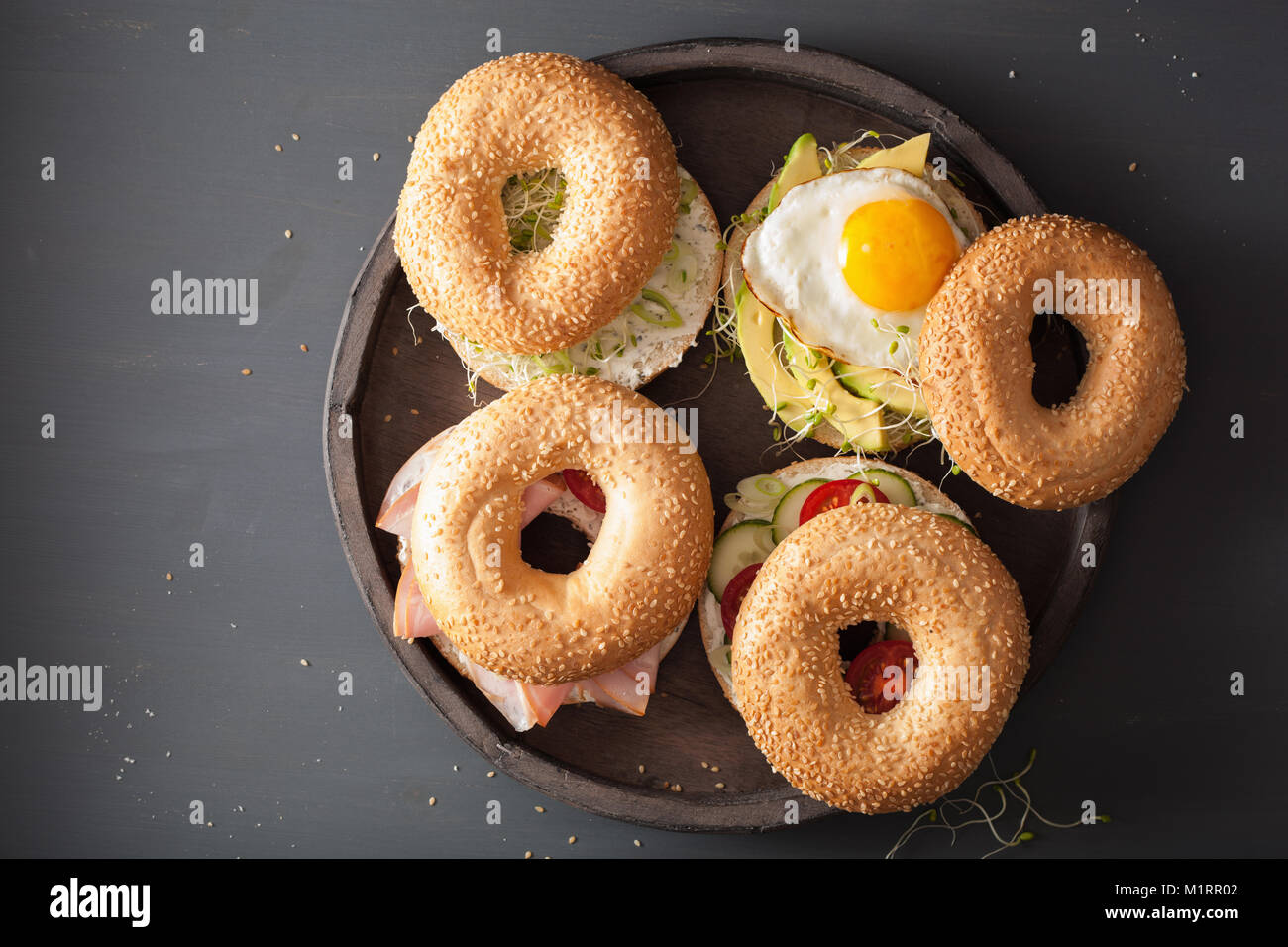 variety of sandwiches on bagels: egg, avocado, ham, tomato, soft cheese ...