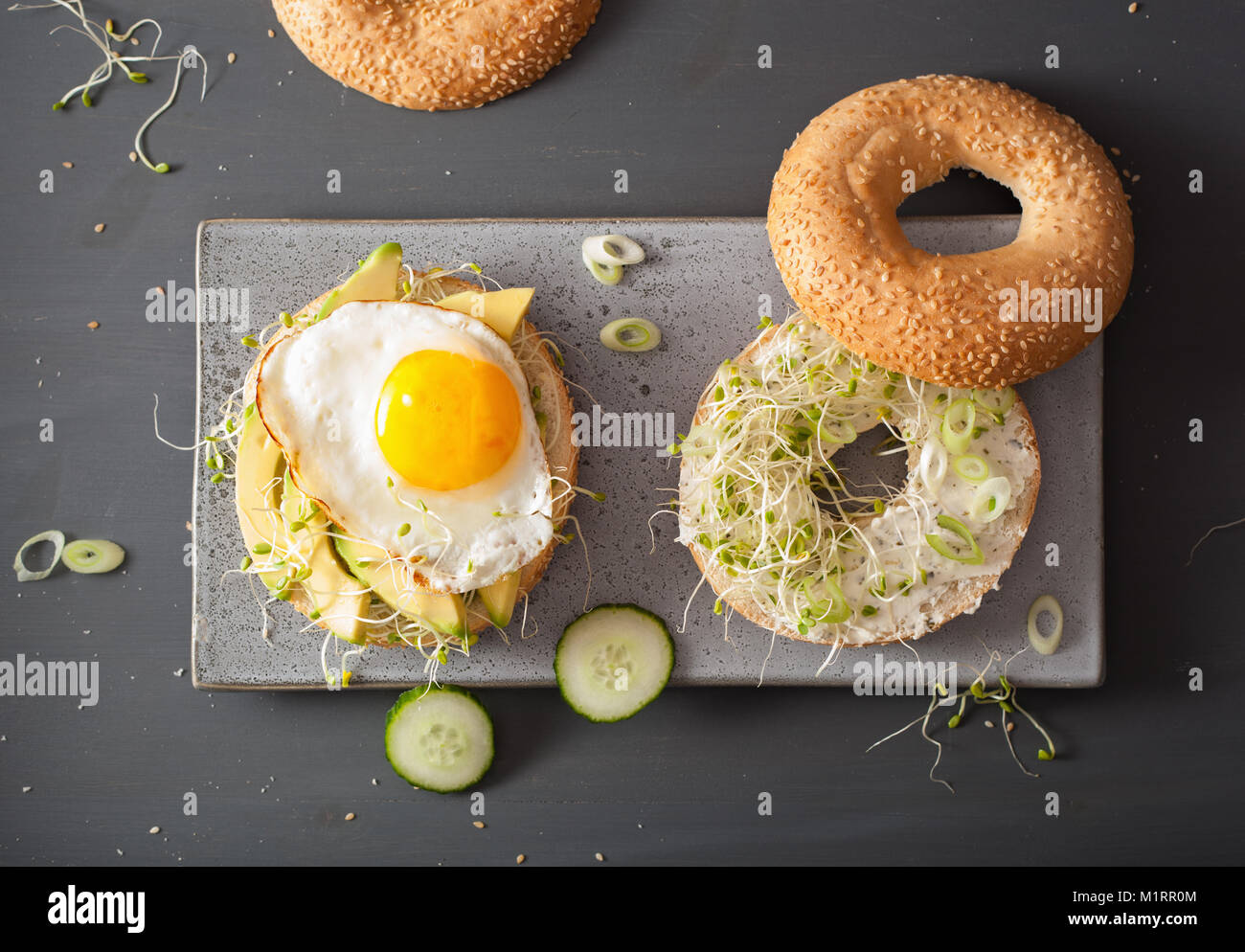 sandwiches on bagels with egg, avocado, soft cheese, alfalfa sprouts ...