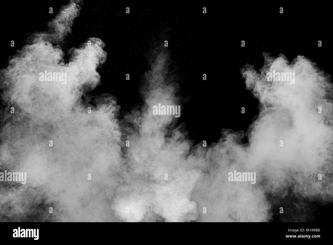 Launched white particle splash on black background Stock Photo - Alamy