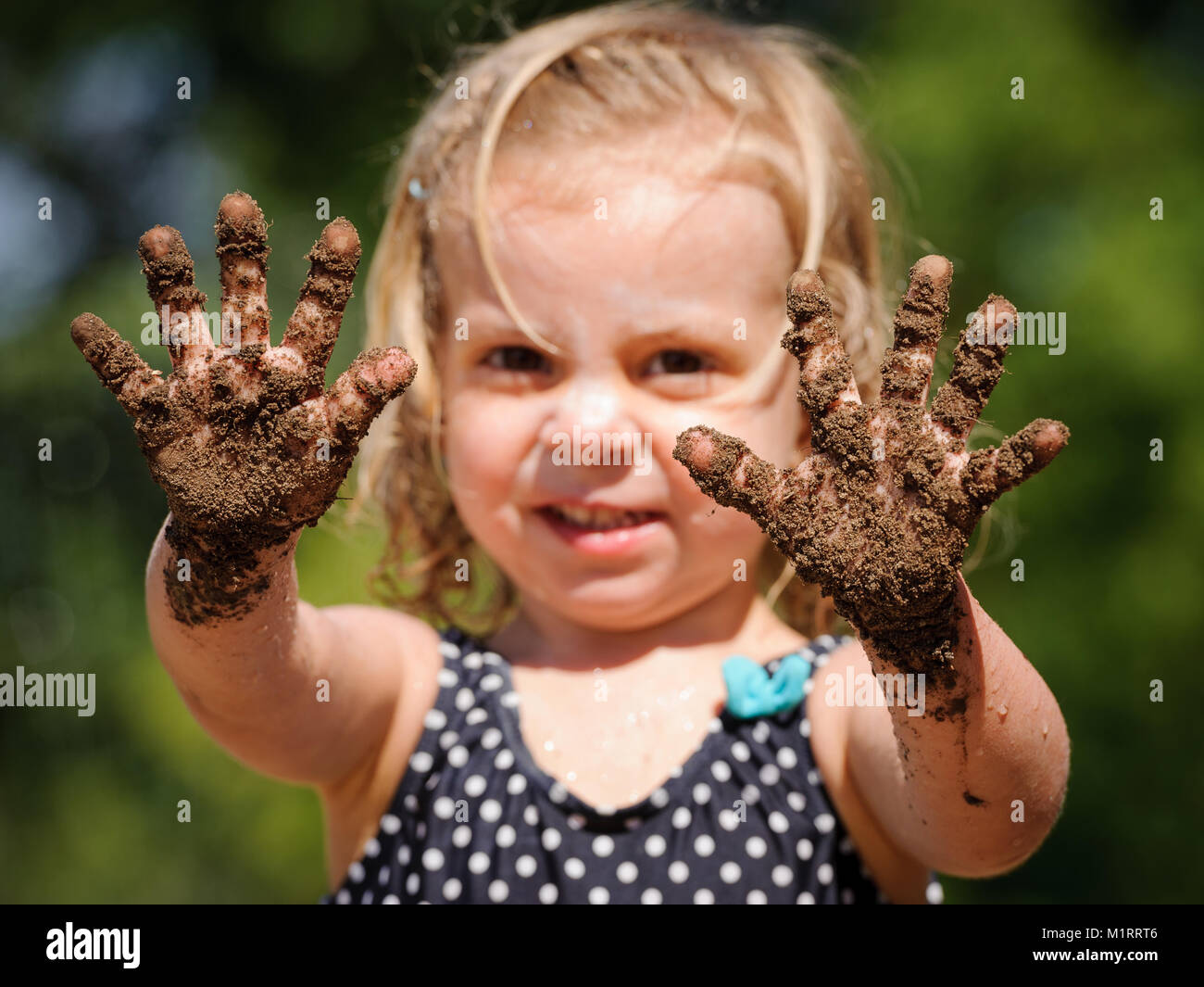 little girl playing in the earth Stock Photo - Alamy