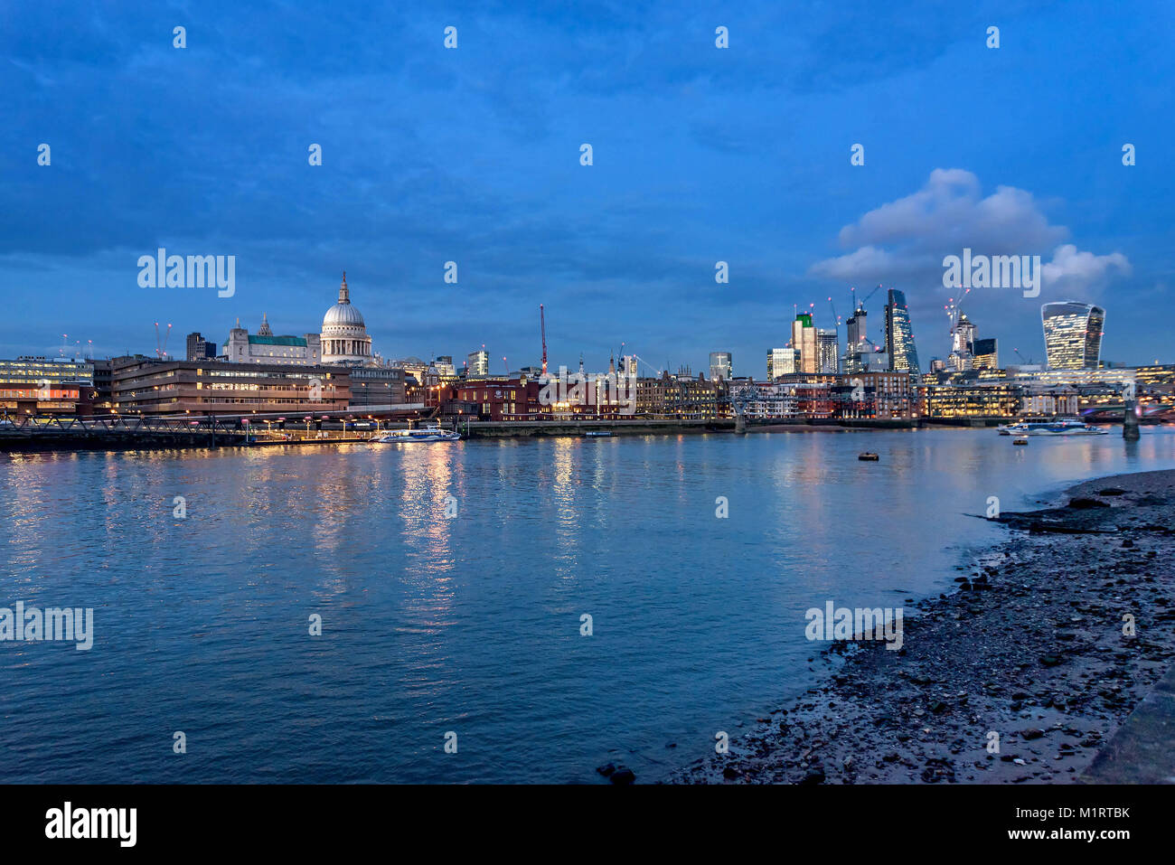 A view at dusk across the River Thames of financial skyscrapers of ...