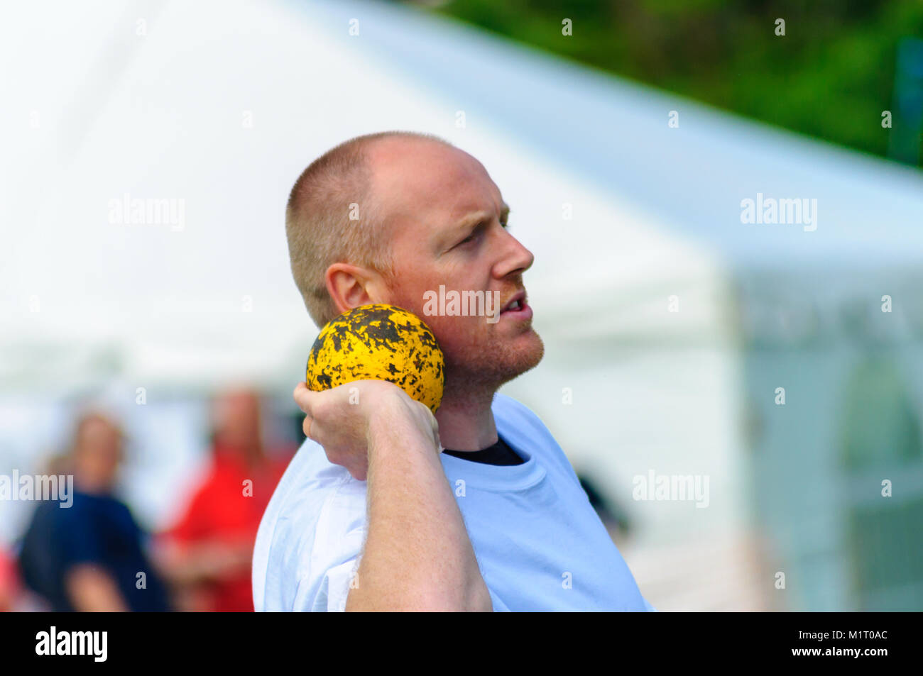 Muscular male prepares to throw in the shot put competition at the ...