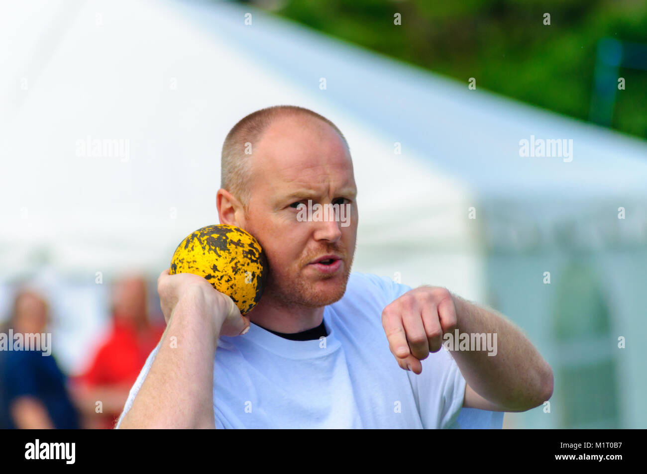 Muscular male prepares to throw in the shot put competition at the ...