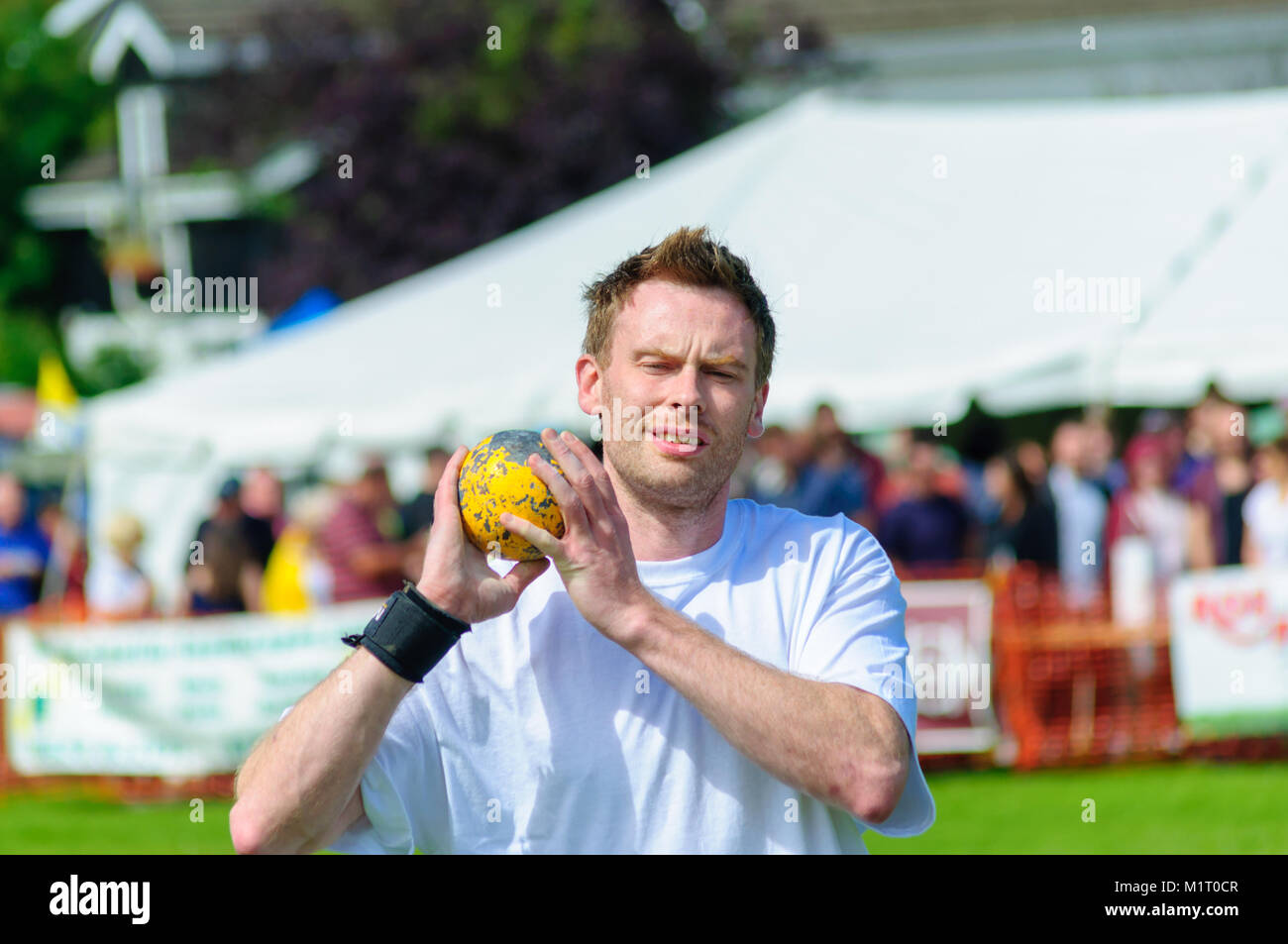 Muscular male prepares to throw in the shot put competition at the ...