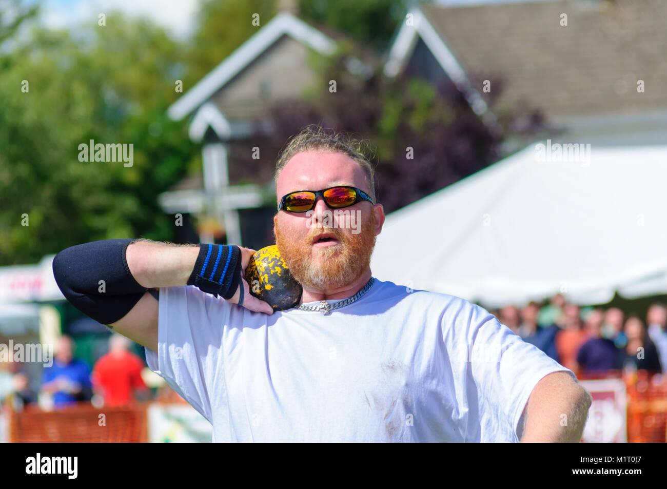 Muscular male prepares to throw in the shot put competition at the ...