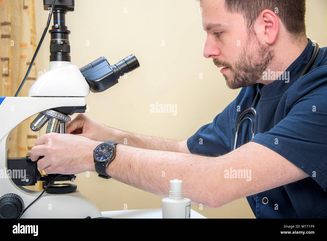 Young doctor researching on a microscope Stock Photo - Alamy