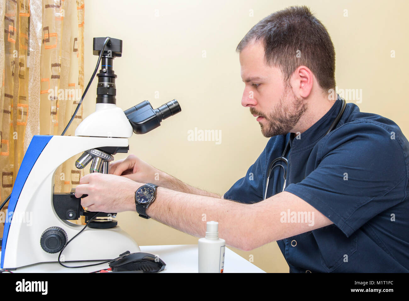 Young doctor researching on a microscope Stock Photo - Alamy