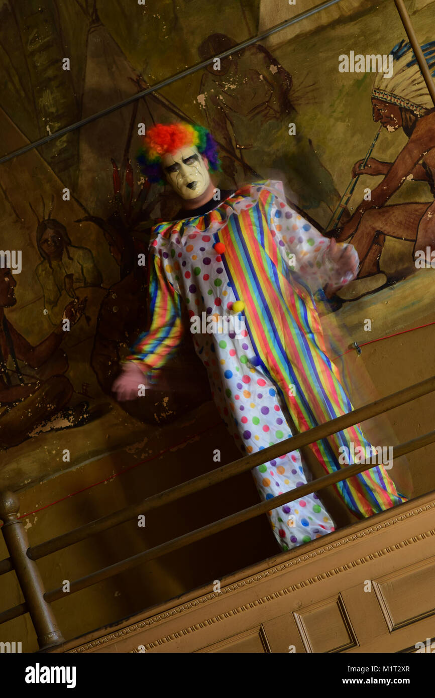 Transparent ghost clown stalking a ruined and abandoned auditorium ...