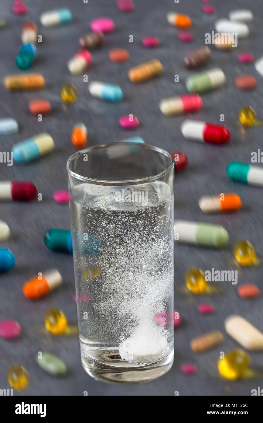 Effervescent tablet in water with bubbles with Multicolored Pills and ...