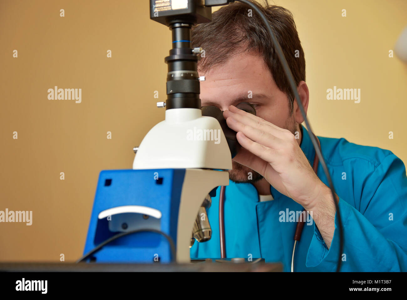 Young doctor researching on a microscope Stock Photo - Alamy