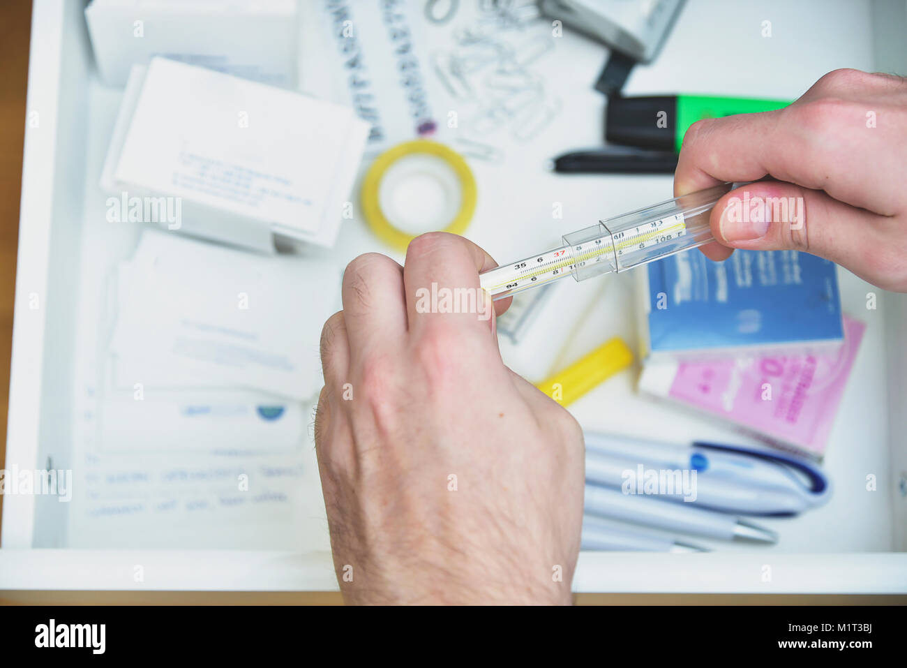 Checking body temperature with a thermometer Stock Photo - Alamy