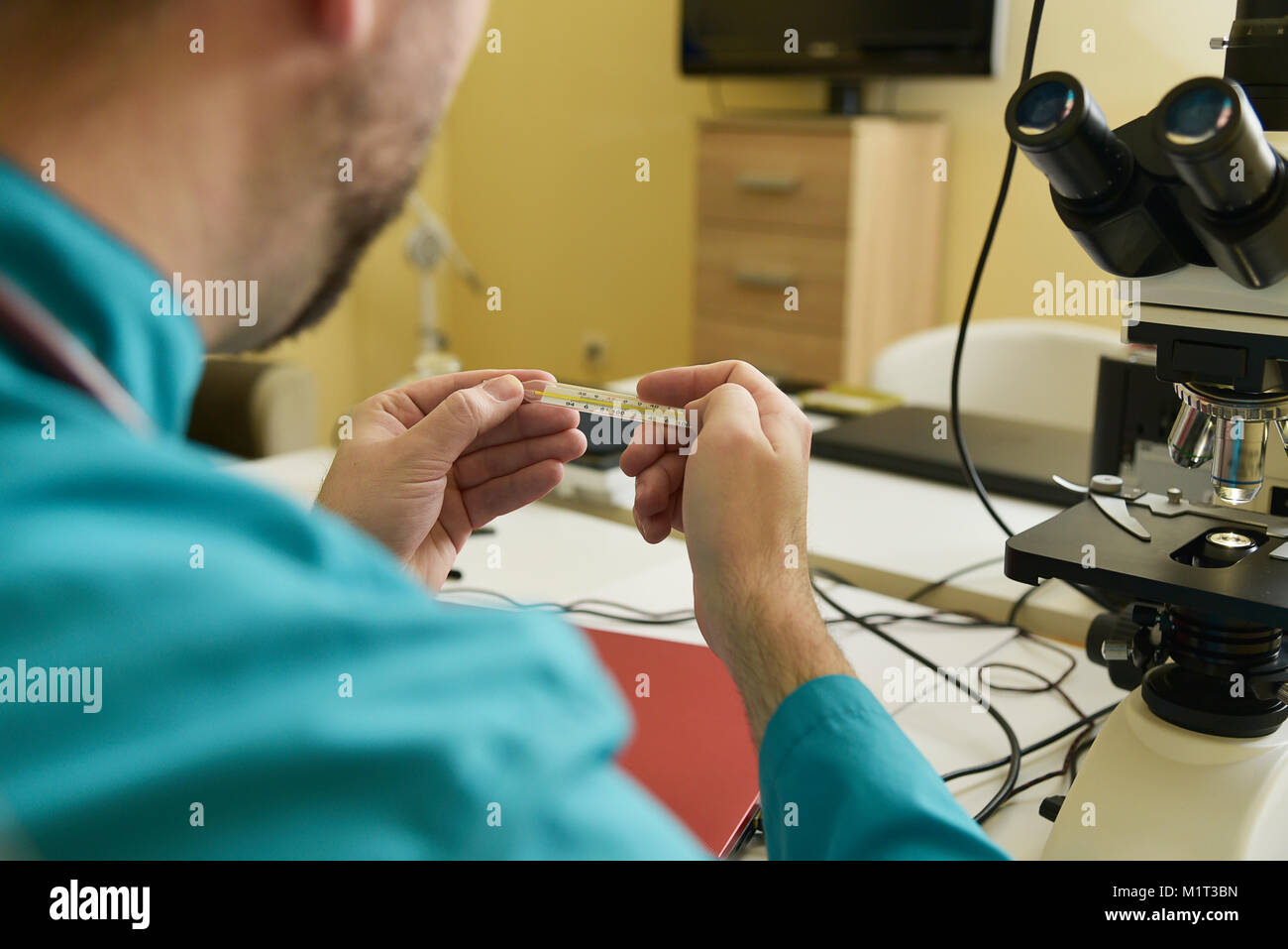 Checking body temperature with a thermometer Stock Photo - Alamy