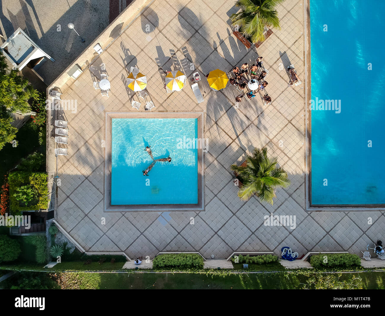 Drone photo of swimming two swimming pools during sunset, with people ...