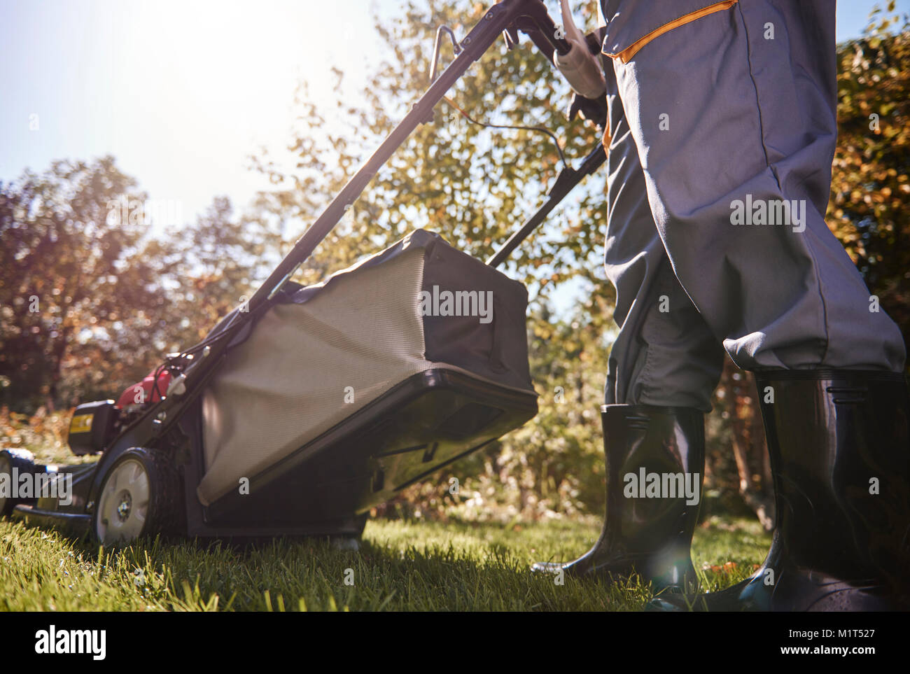 Unrecognizable man cutting the grass Stock Photo - Alamy