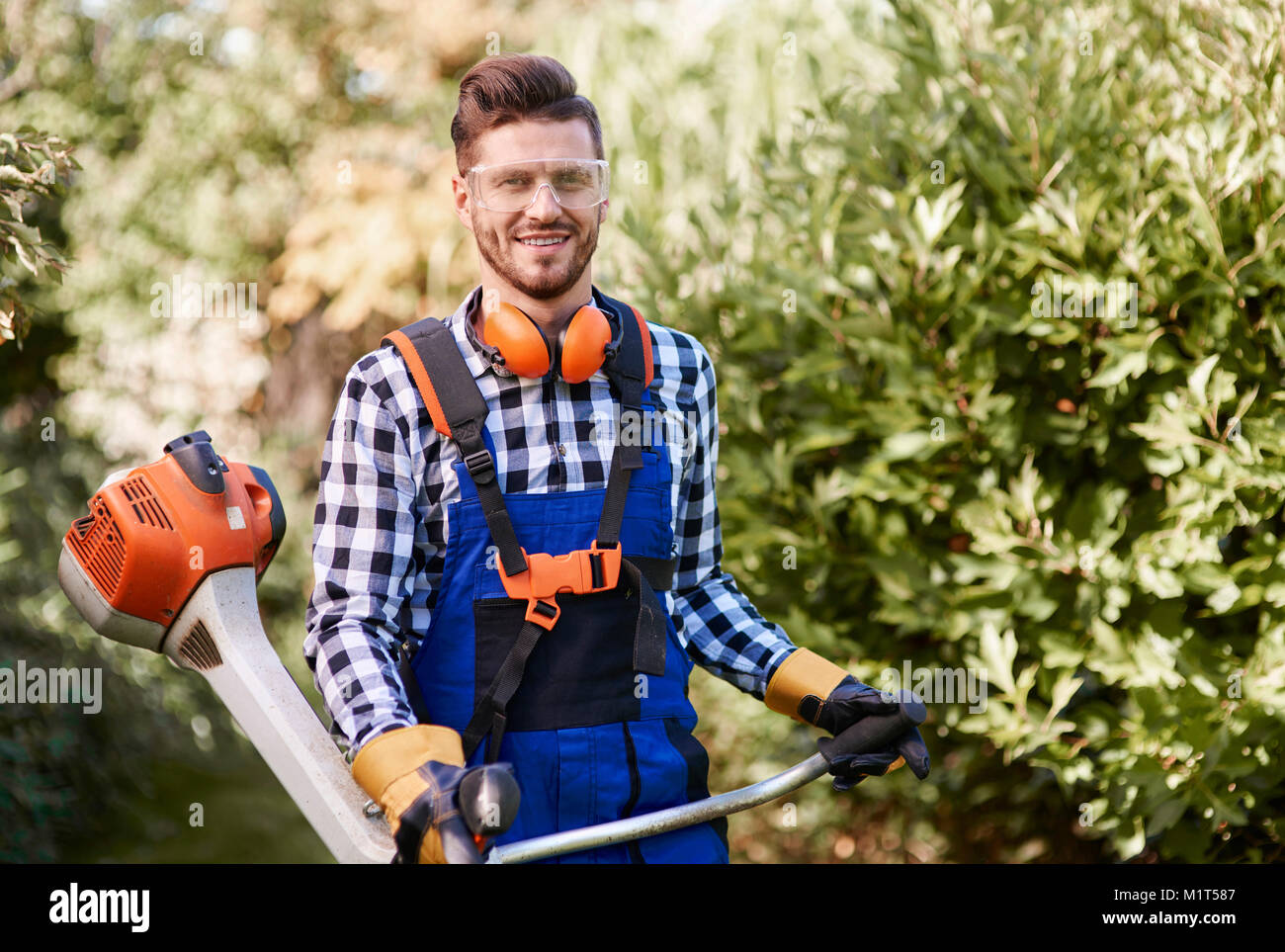Portrait of man working with weedwacker Stock Photo - Alamy