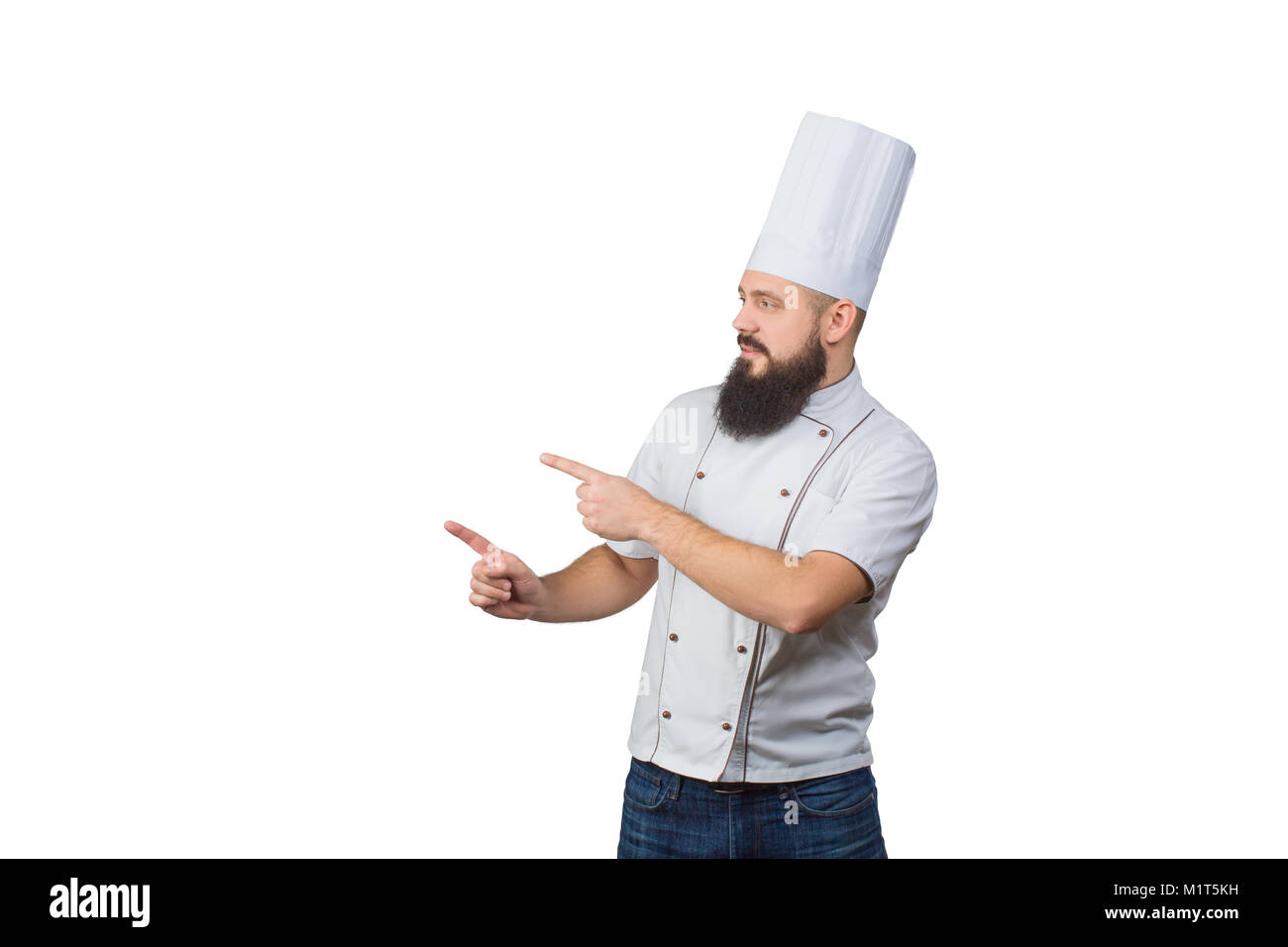 Charming young male chef cook pointing fingers in white uniform over ...