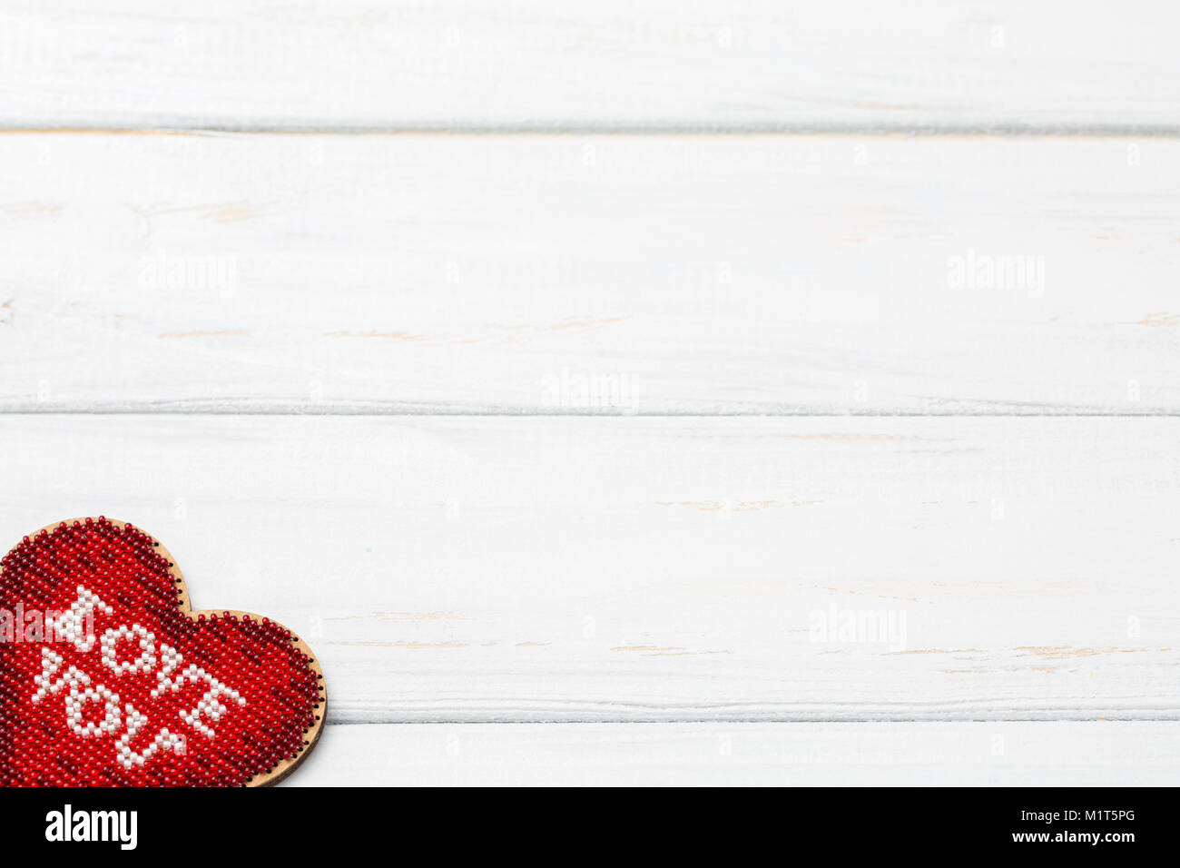 The model hart shape red color inside lay down on white wooden surface ...