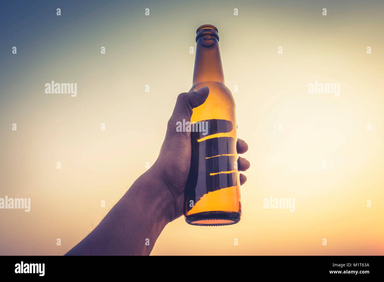 hand holding beer bottle Stock Photo - Alamy