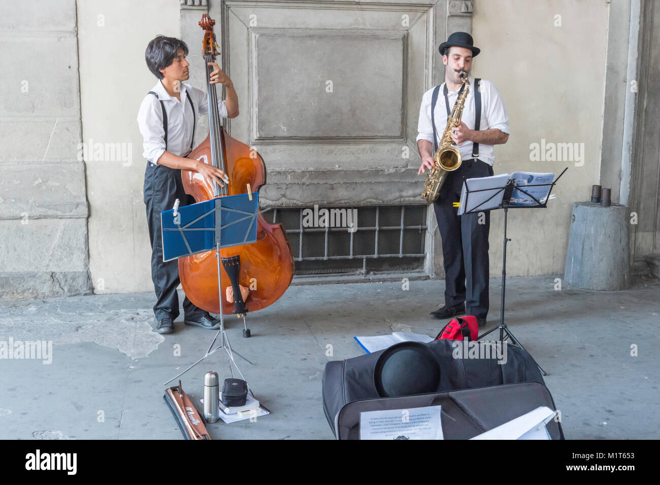 Two male street musicians playing a cello and saxophone close to the ...