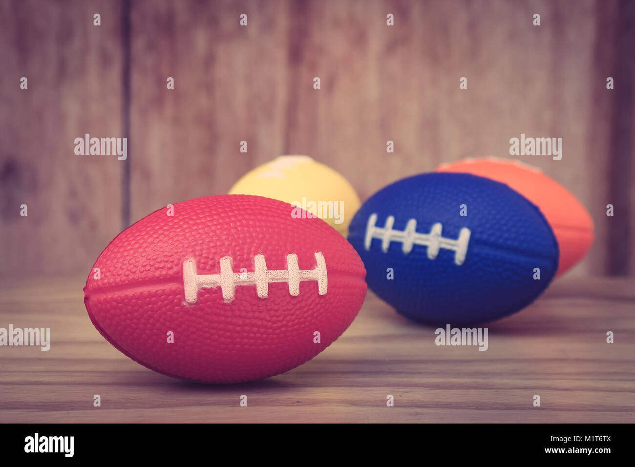 Close up red rugby ball toy for children laying on wooden floor with ...