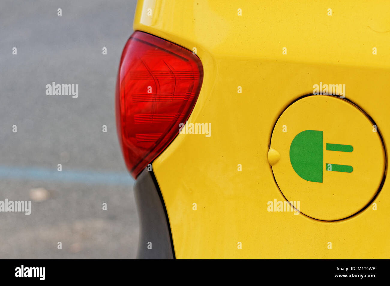 Yellow electric car with plug logo Stock Photo - Alamy