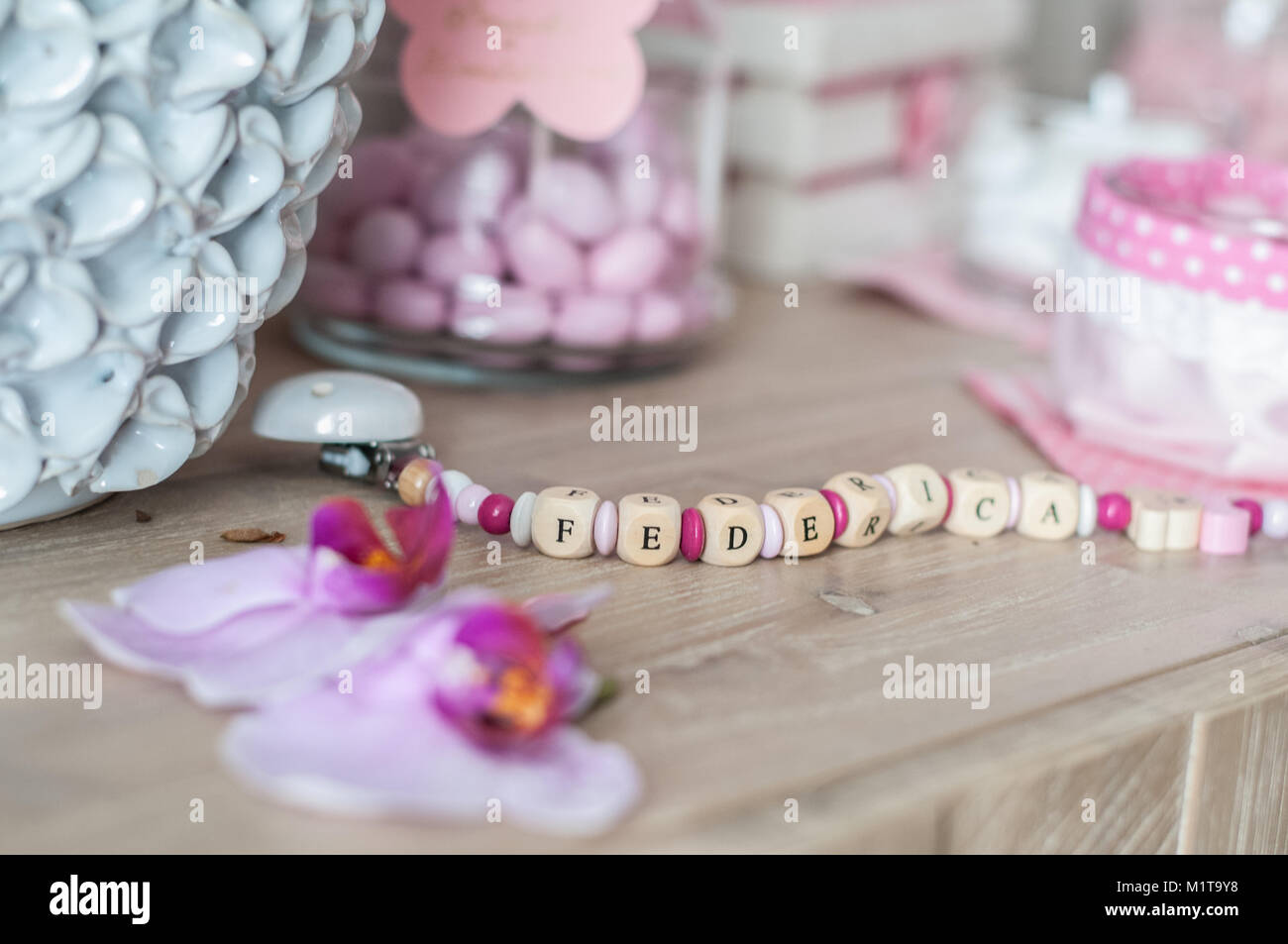 newborn girl table set with glass containers with different pink ...