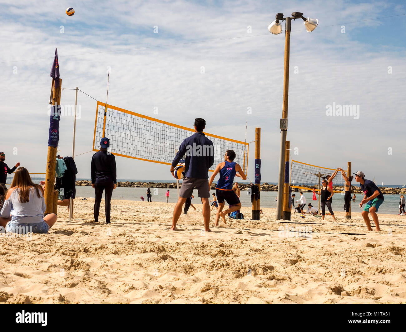 Tel Aviv, Israel. Group of young people playing volleyball on the beach ...