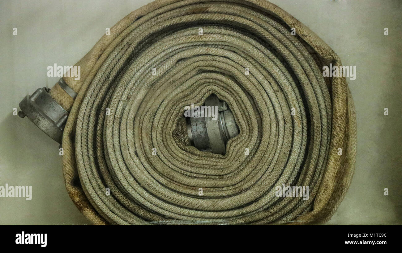 Spiral fire hose in place dirty Stock Photo - Alamy