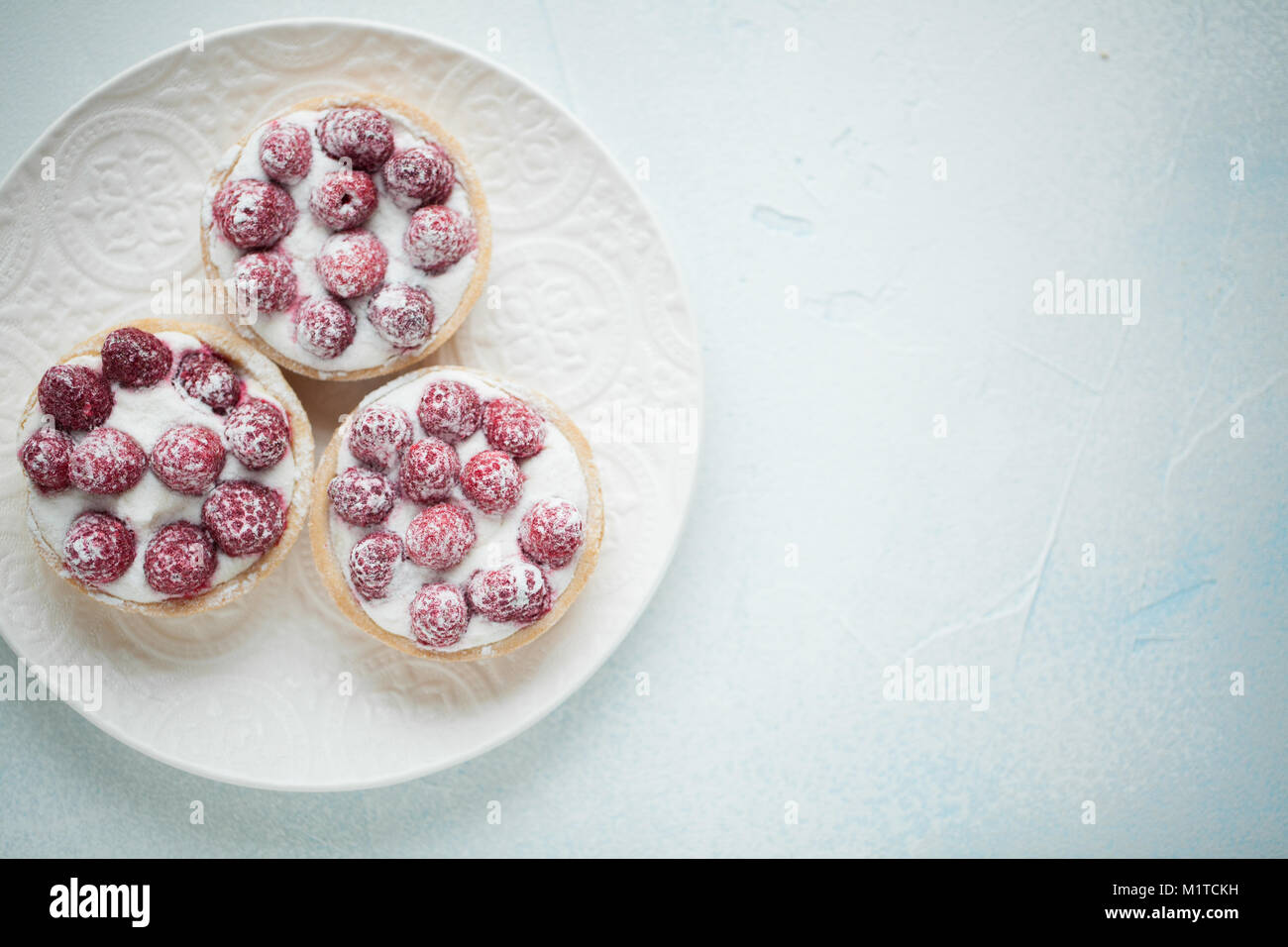 Delicious raspberry tartlets on a white vintage plate. Sweet treat on a ...