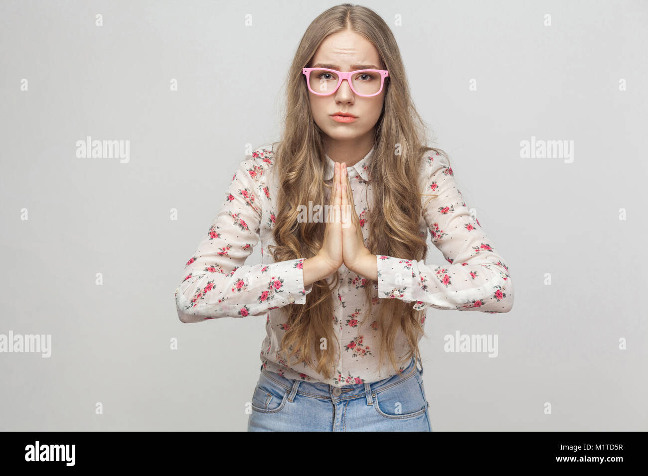 Please sorry. Woman apologize and have a unhappy look. Studio shot ...