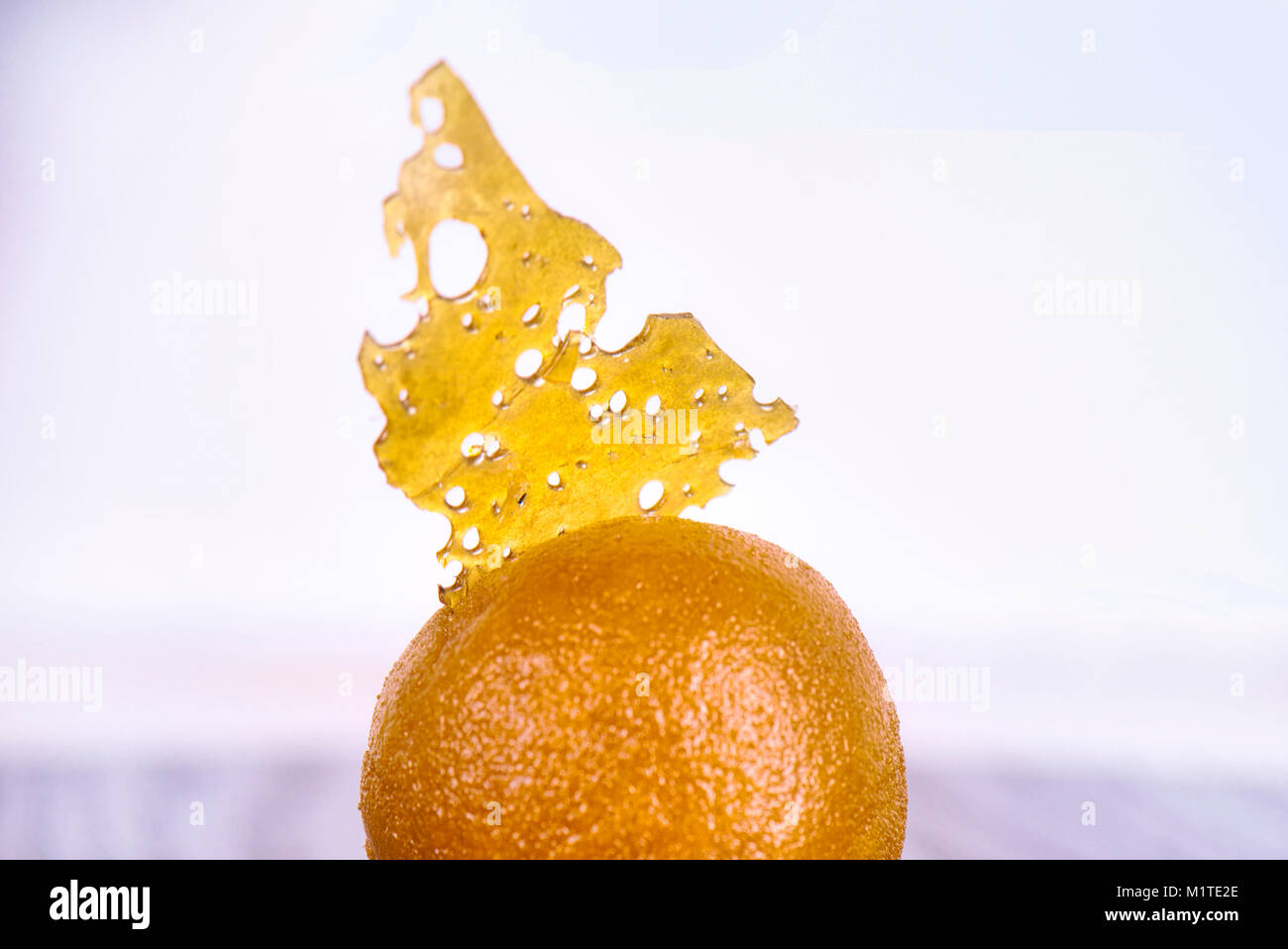 Detail of cannabis oil (aka shatter) and live resin in a ball shape ...