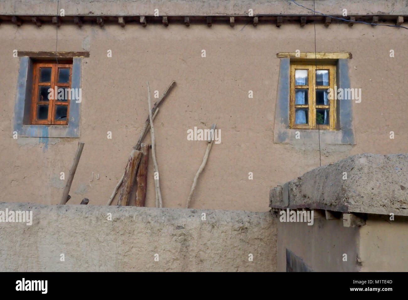 Pink clay wall, a clay fence, small wooden windows create a design ...