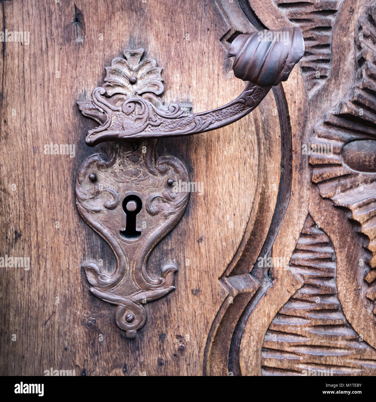 Detail of a carved wooden portal with wrought iron handle and key hole ...