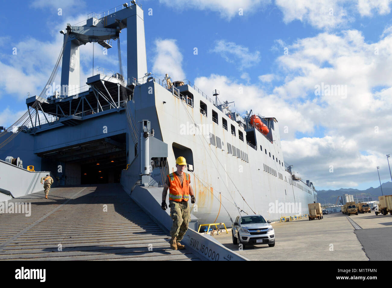 A Sailor assigned to a Navy Cargo Handling Battalion walks down the ...