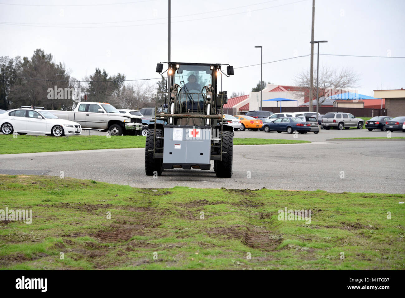 An Airman from the 60th Civil Engineer Squadron uses a tractor to move ...