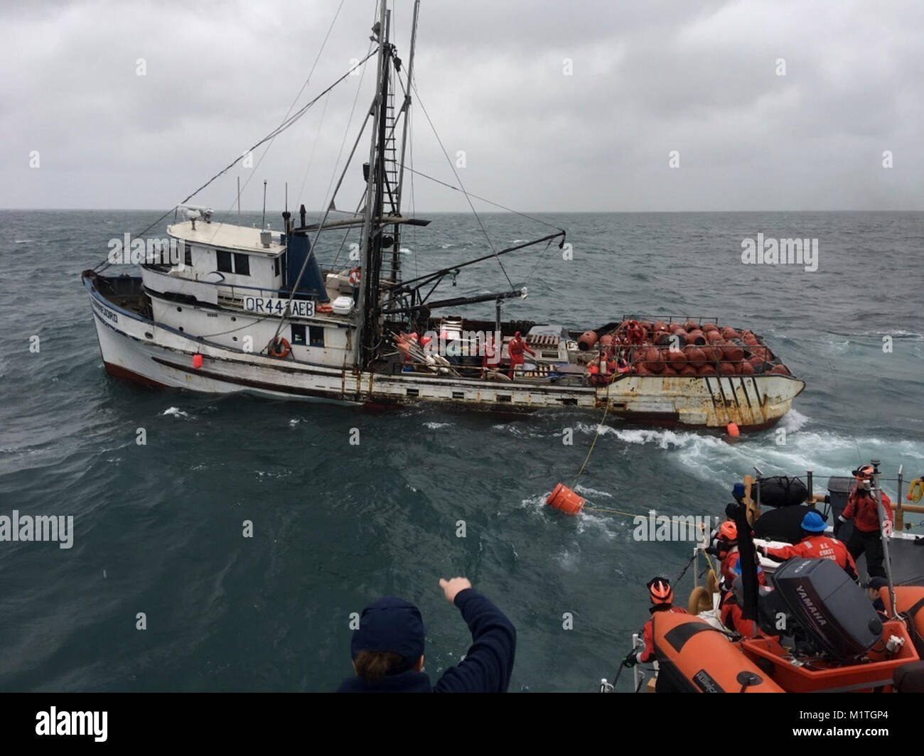 The crew of the Coast Guard Cutter Cuttyhunk pass two dewatering pumps ...