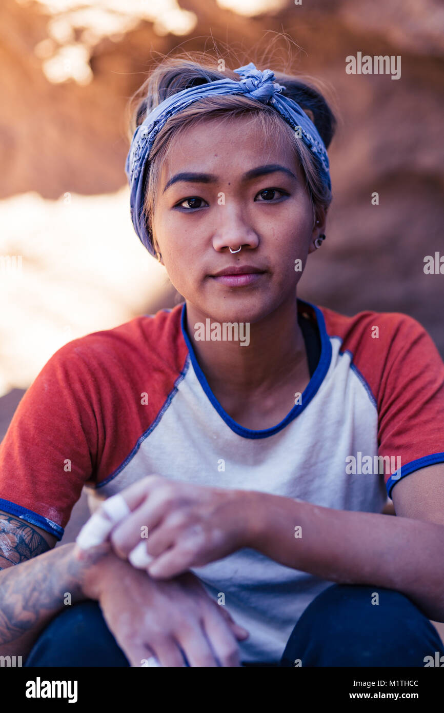 Portrait of a young asian woman during an outdoor rock climb in the ...