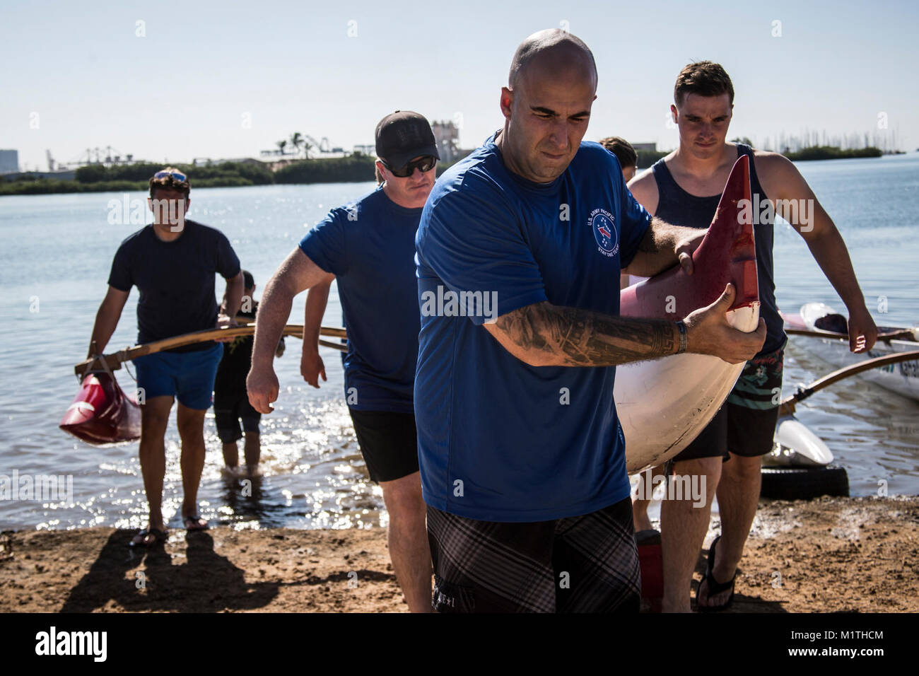 Outrigger canoeing boat team lifts their outrigger canoe from the water ...