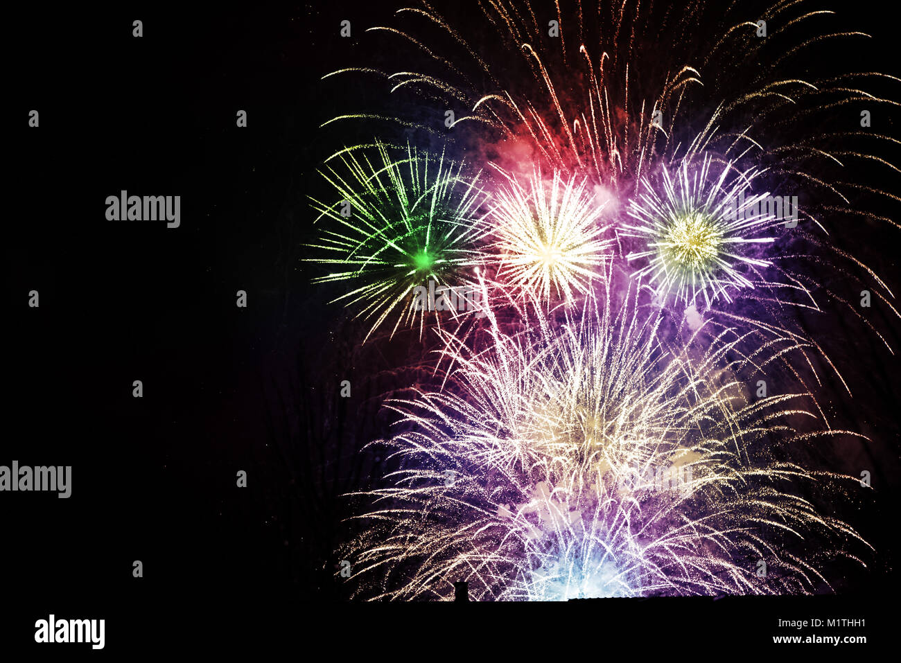 Colorful, beautiful fireworks on the night sky over the city. New Year ...