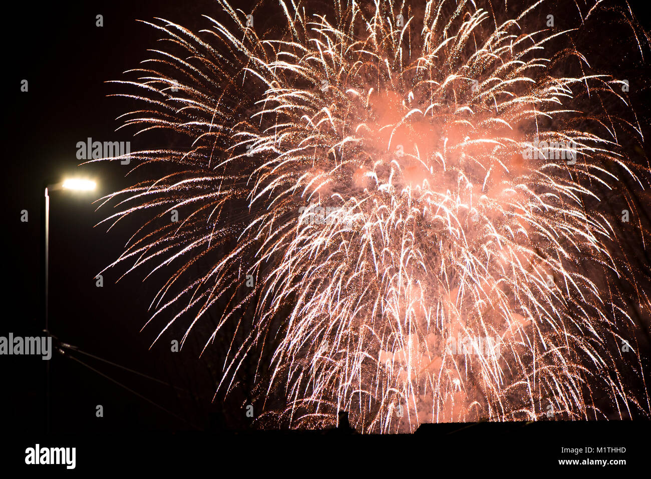 Colorful, beautiful fireworks on the night sky over the city. New Year ...