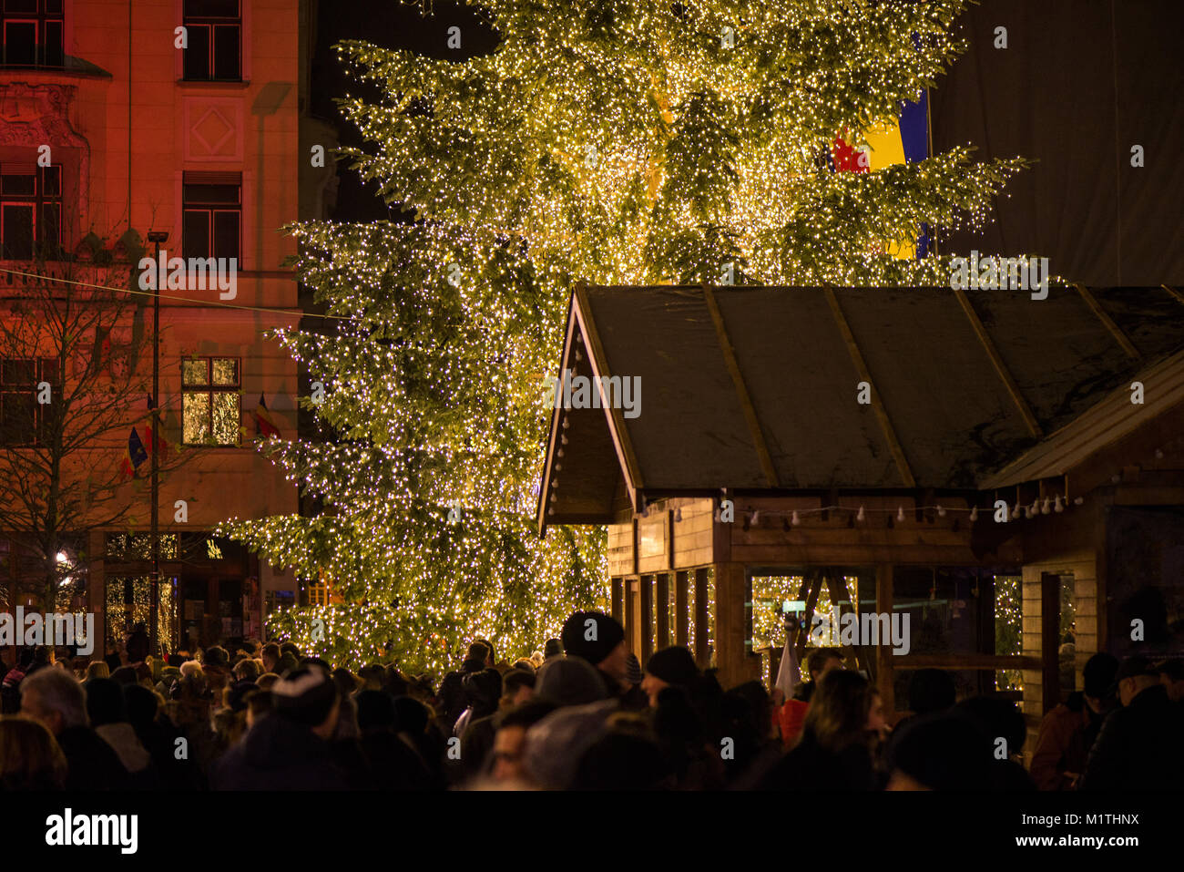 Crowded Christmas market in city center. Decorated Christmas tree with ...