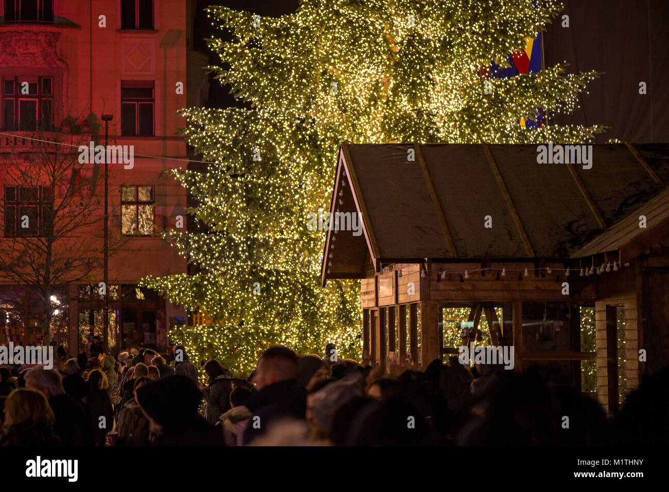 Crowded Christmas market in city center. Decorated Christmas tree with ...