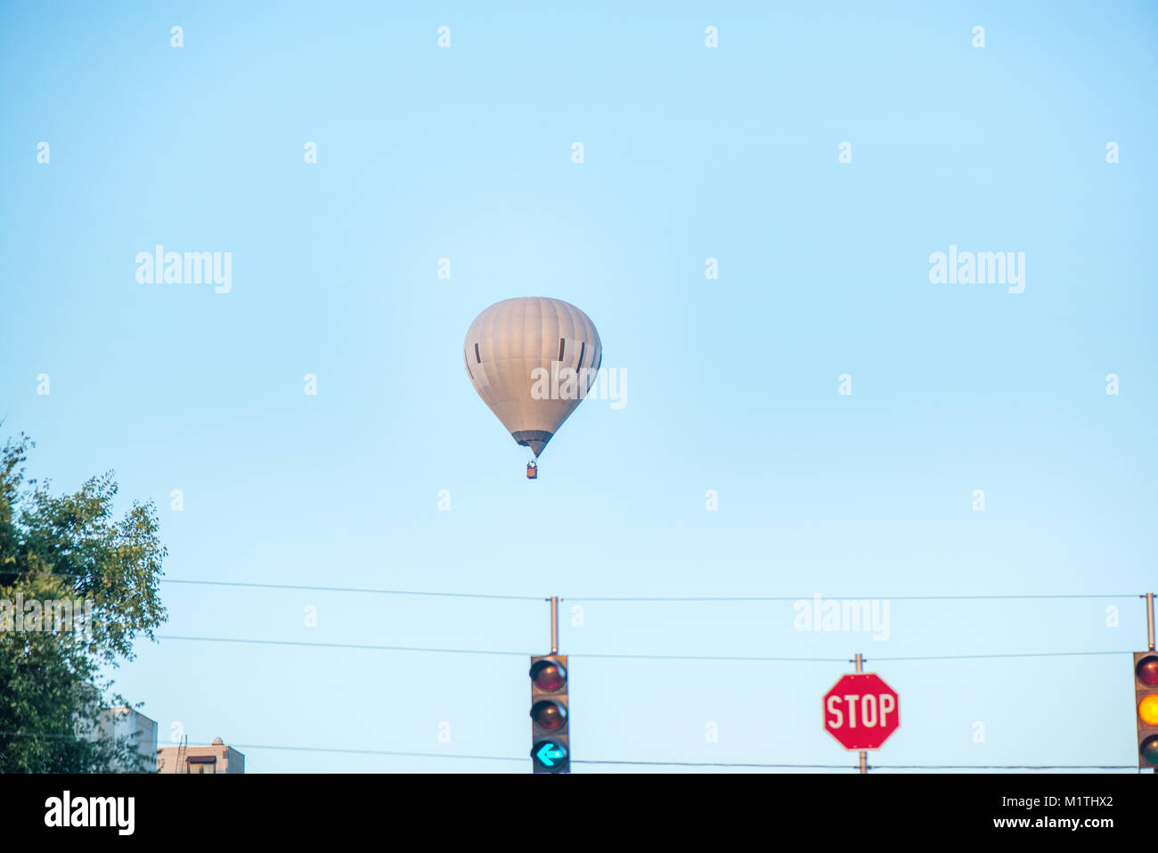 Hot air balloon flying high in the air on clear blue sky background ...